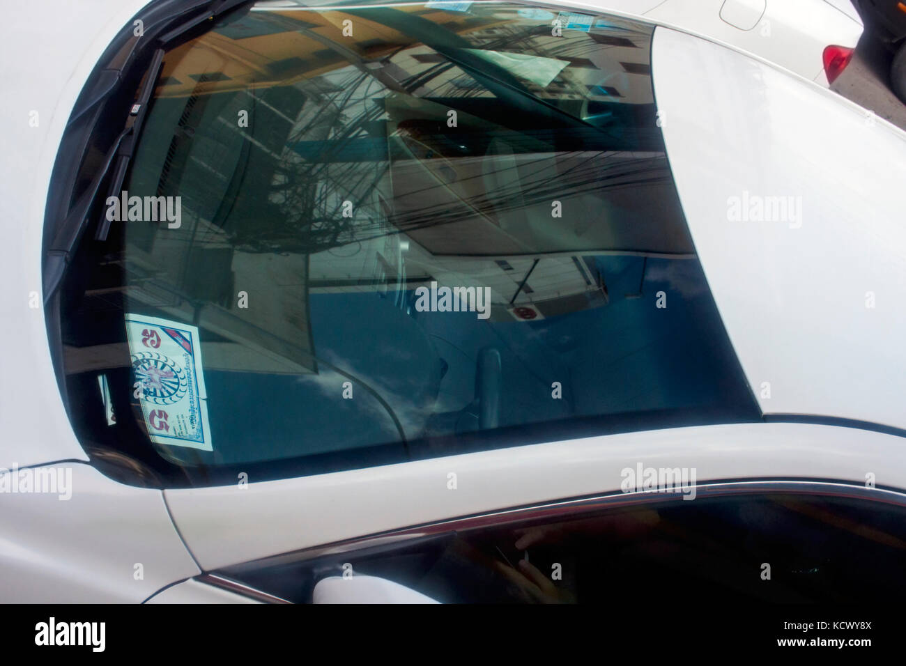 The windshield of a car is seen from above on a city street in Phnom ...