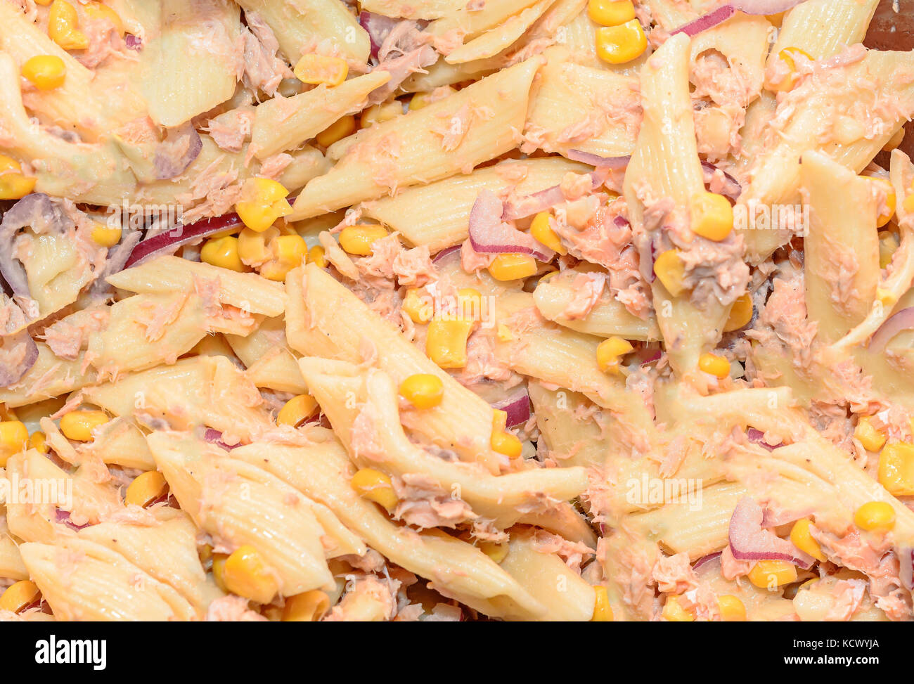 Cooked pasta with red onion, tuna and corn, transparent plate isolated ...