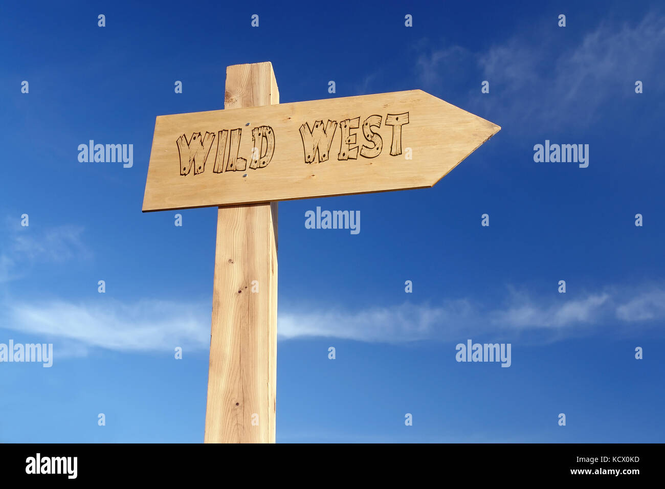 Wooden signpost indicating Wild West direction over blue sky Stock ...