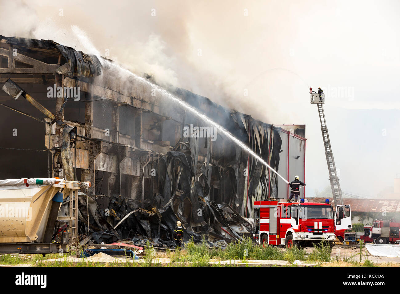 Fire disaster in a warehouse. Fire fighting in an industrial area. Red ...