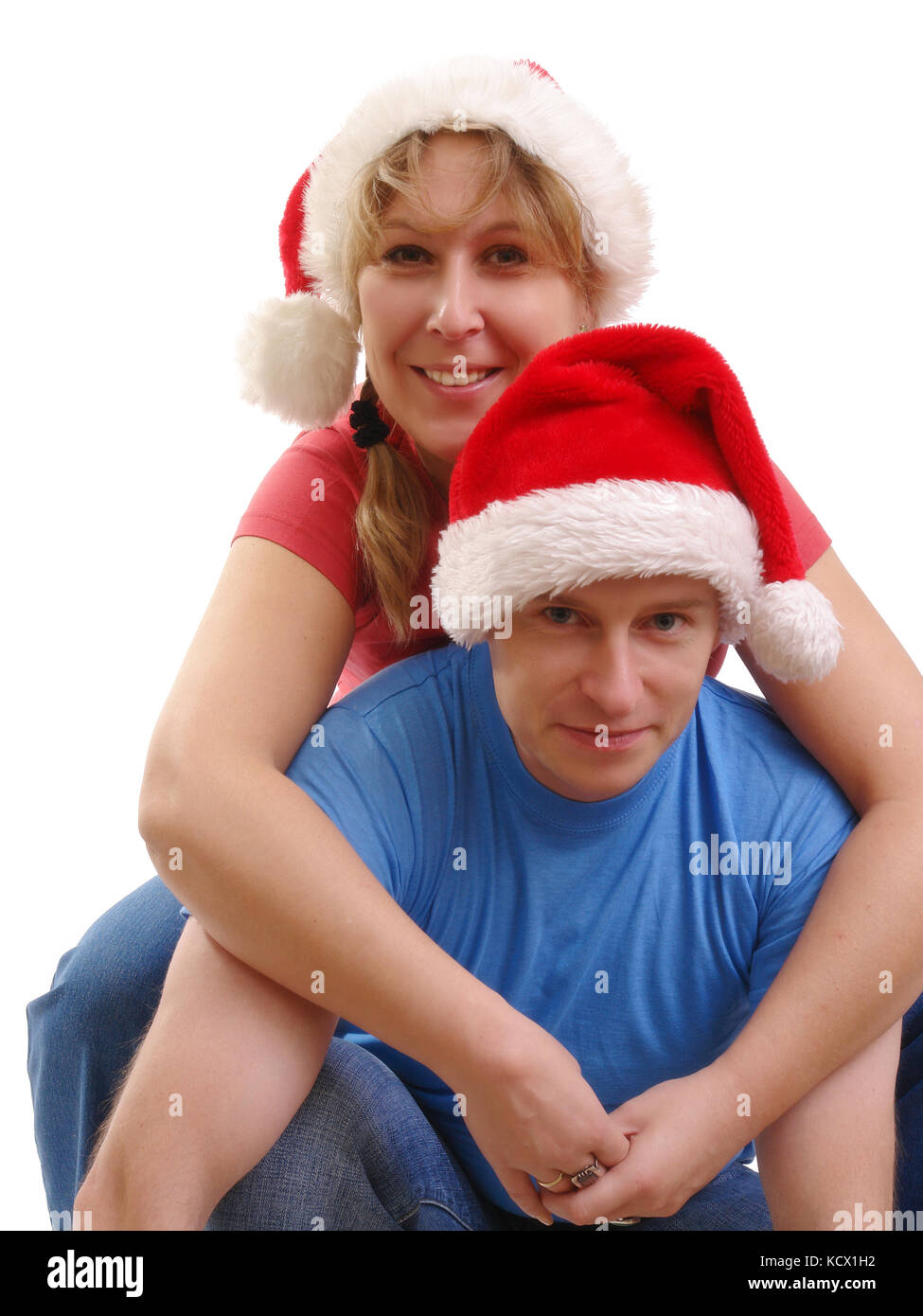 Young happy couple wearing red santa hats posing over white background ...