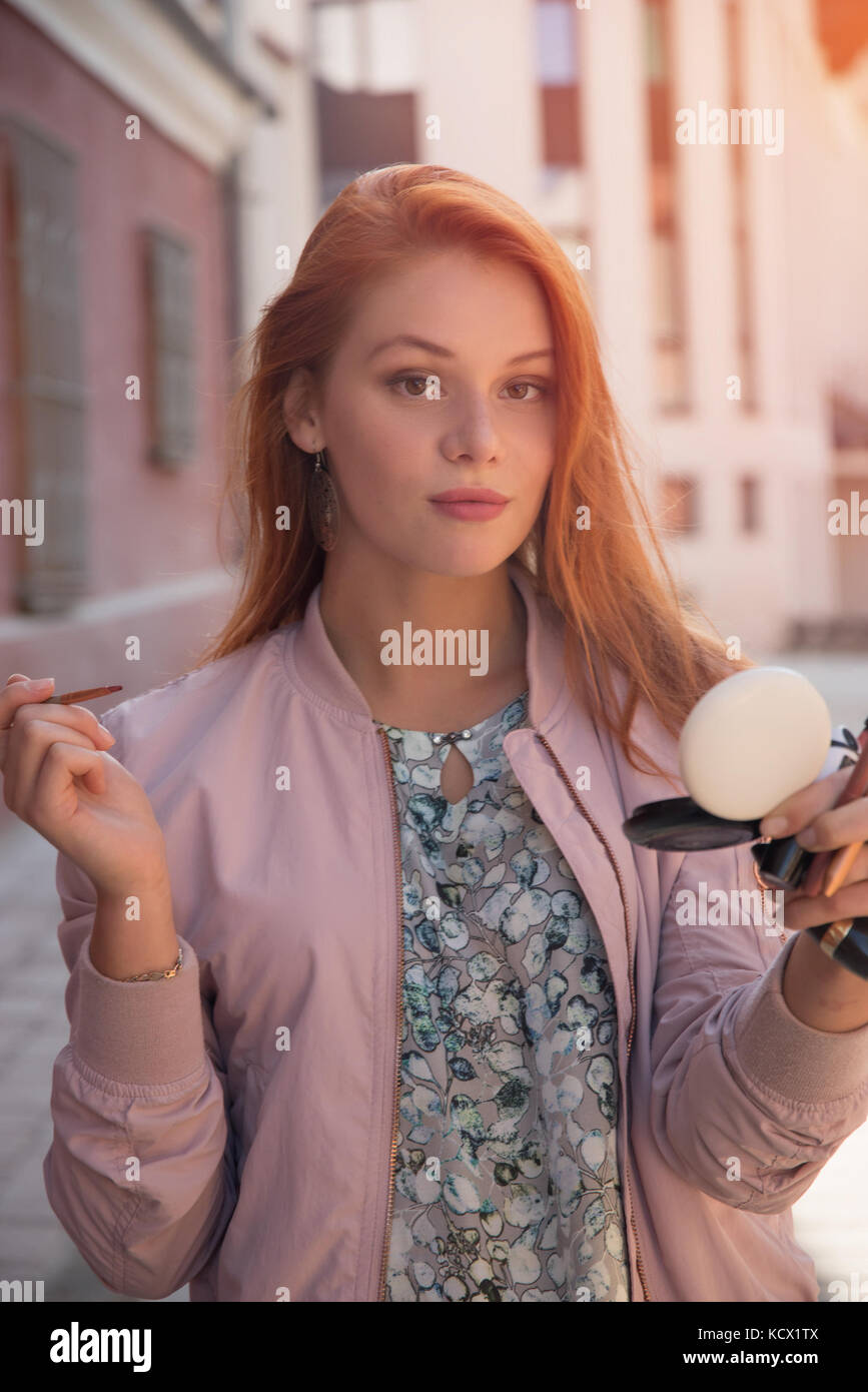 girl doing makeup on the street. Colour lips Stock Photo - Alamy