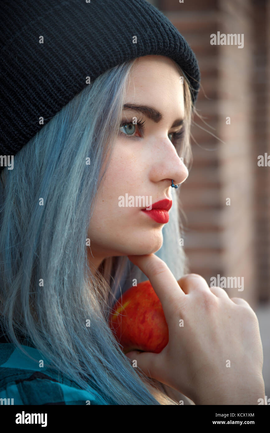 girl with blue hair eating an apple Stock Photo - Alamy