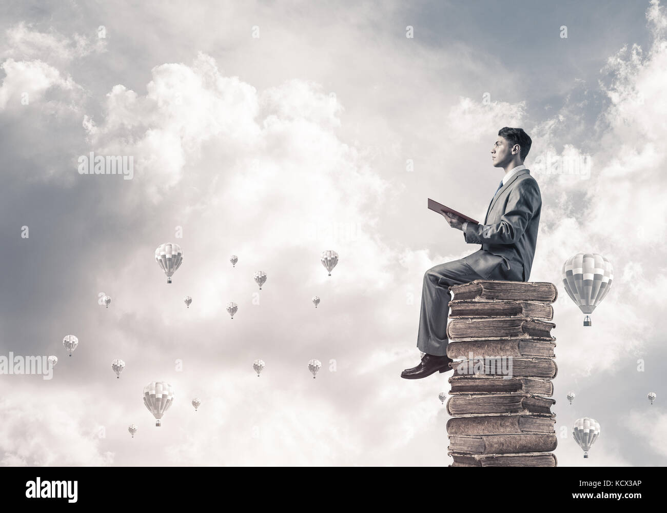 Man student reading book and aerostats flying around in air Stock Photo ...