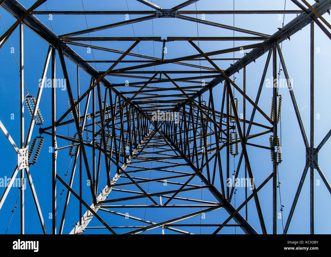 Looking up from inside an electricity pylon, on the background of a ...