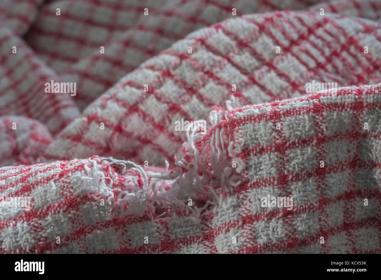 Close-up shot of the frayed edges of an old teacloth. Worn fabric ...