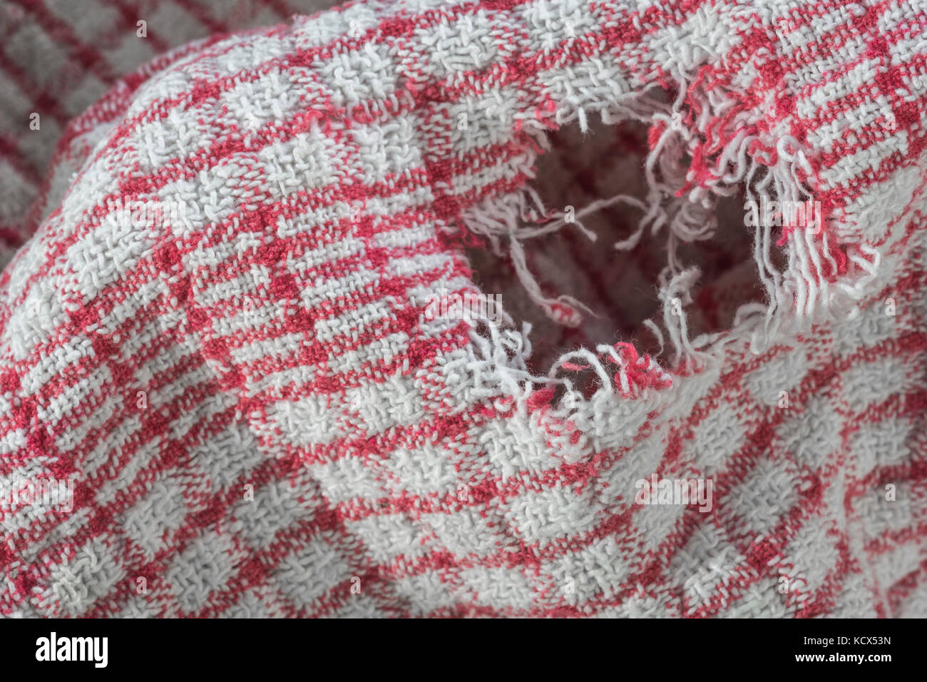 Close-up shot of the frayed edges of an old teacloth. Worn fabric ...