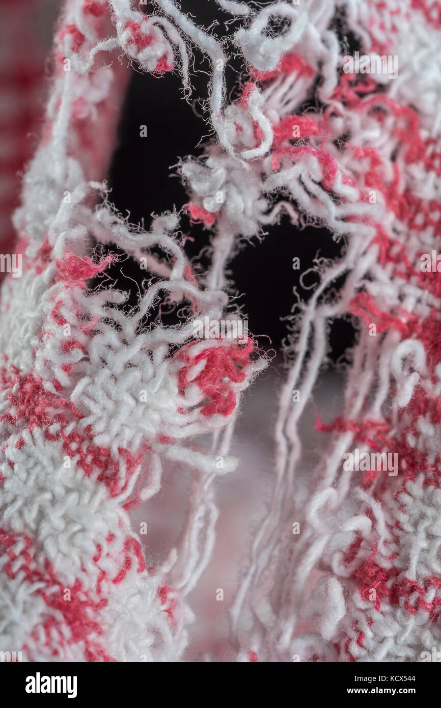 Close-up shot of the frayed edges of an old teacloth. Worn fabric ...