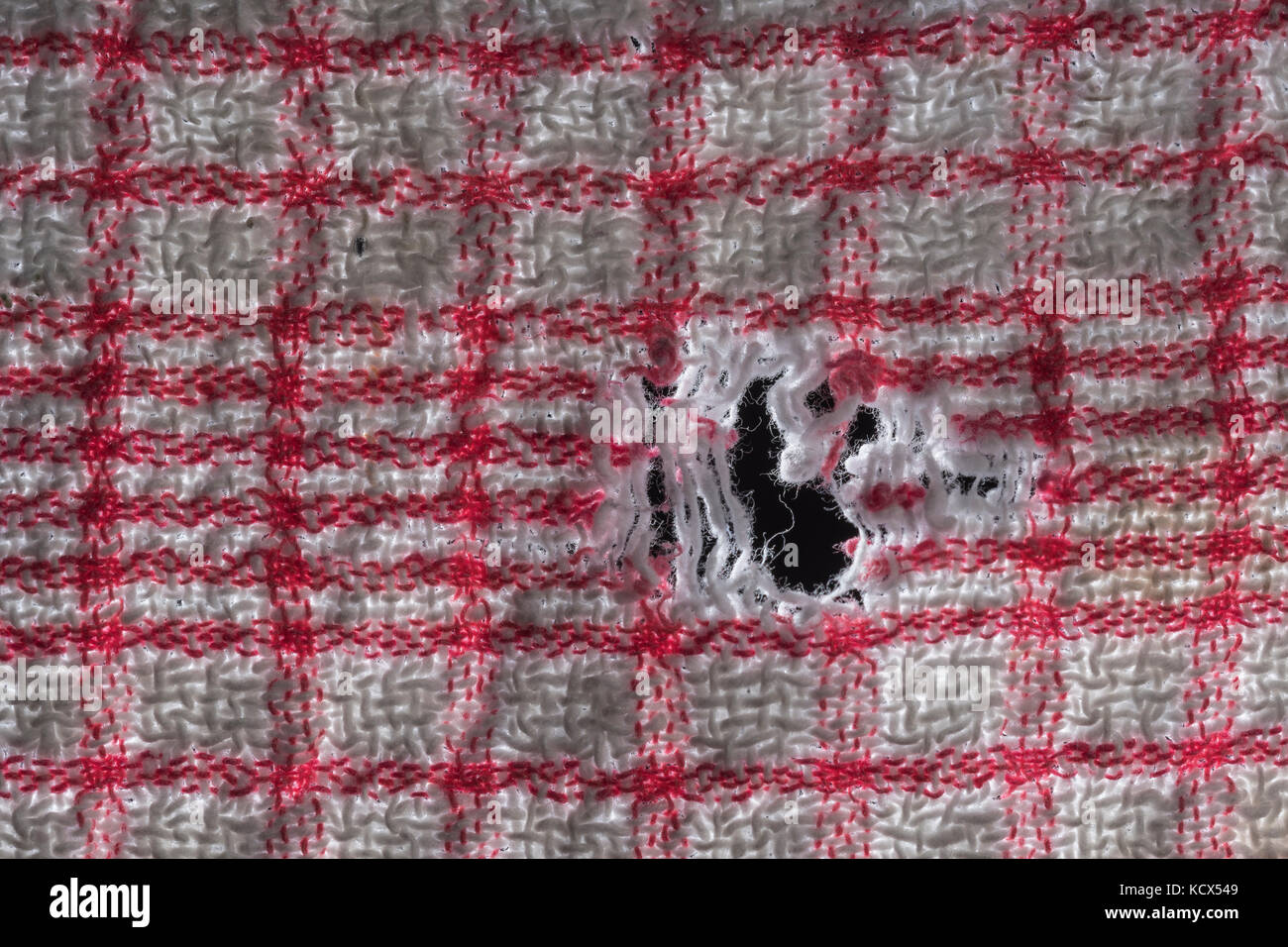 Close-up shot of the frayed edges of an old teacloth. Worn fabric ...