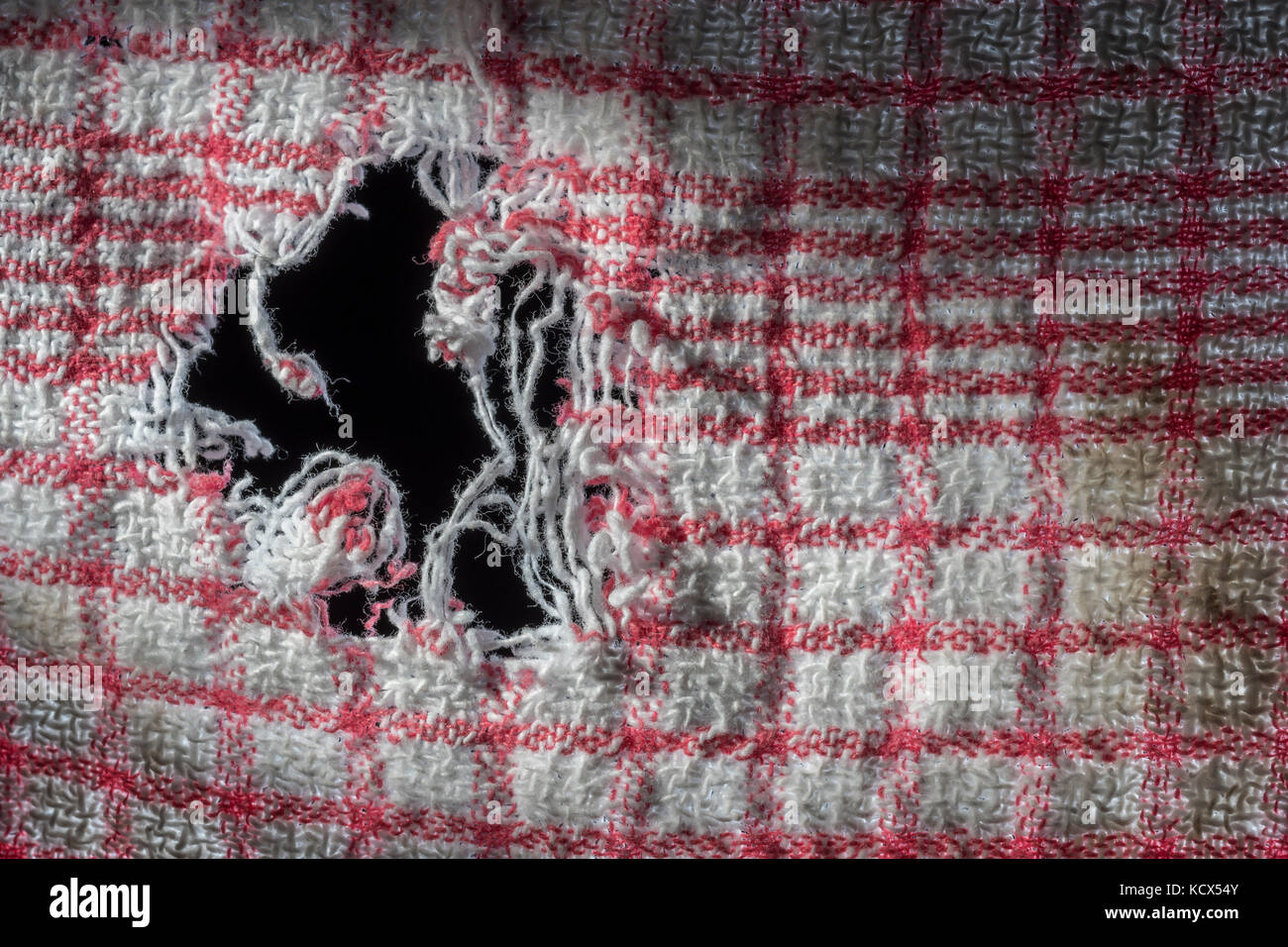 Close-up shot of the frayed edges of an old teacloth. Worn fabric ...