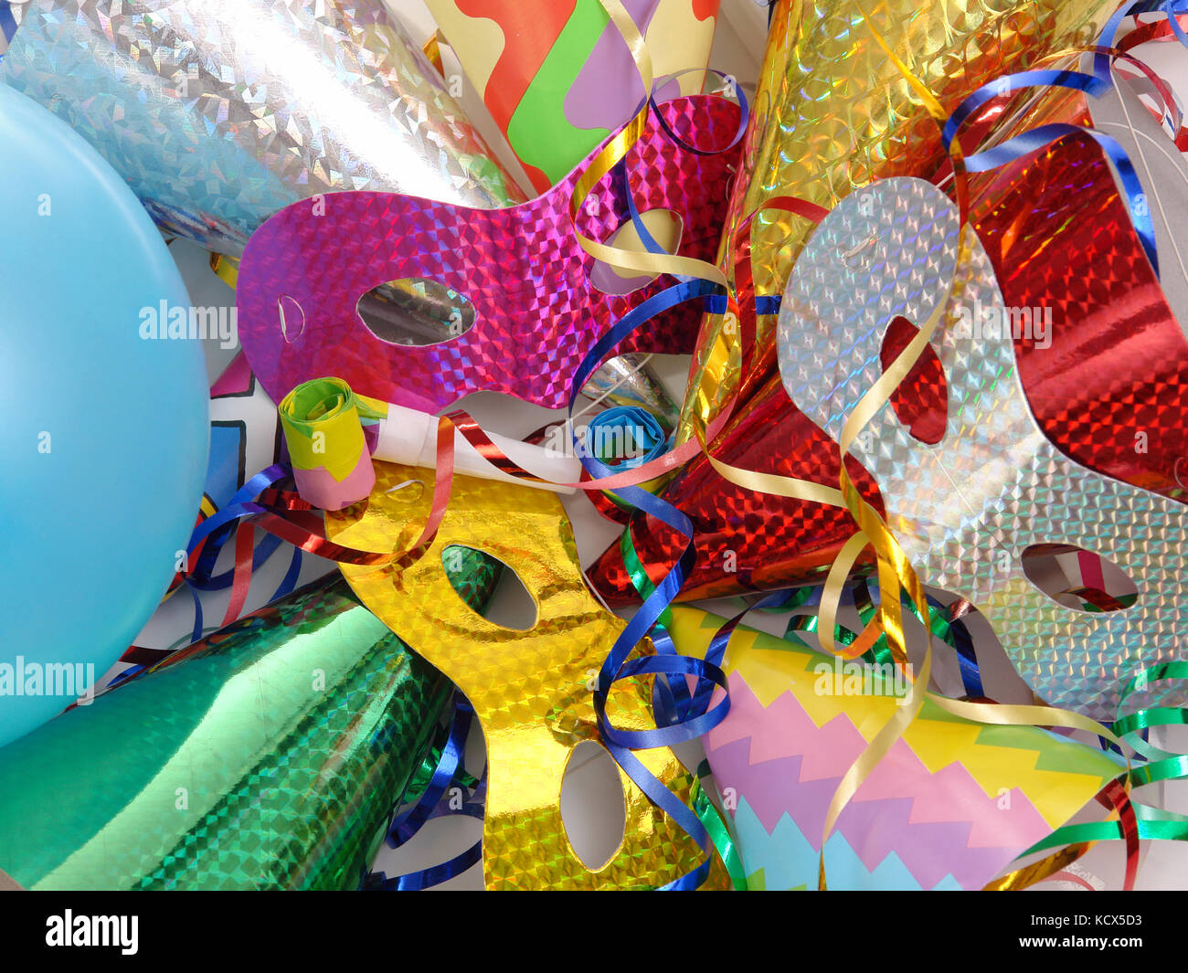 Closeup of cone party hats, balloon, pipe, streamers and carnival masks ...