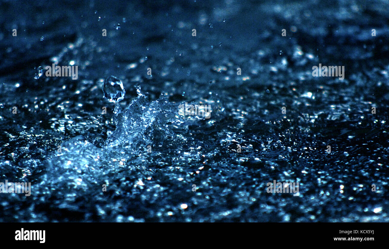 picture of a Water drops levitating in the air in dark. Splashing water ...