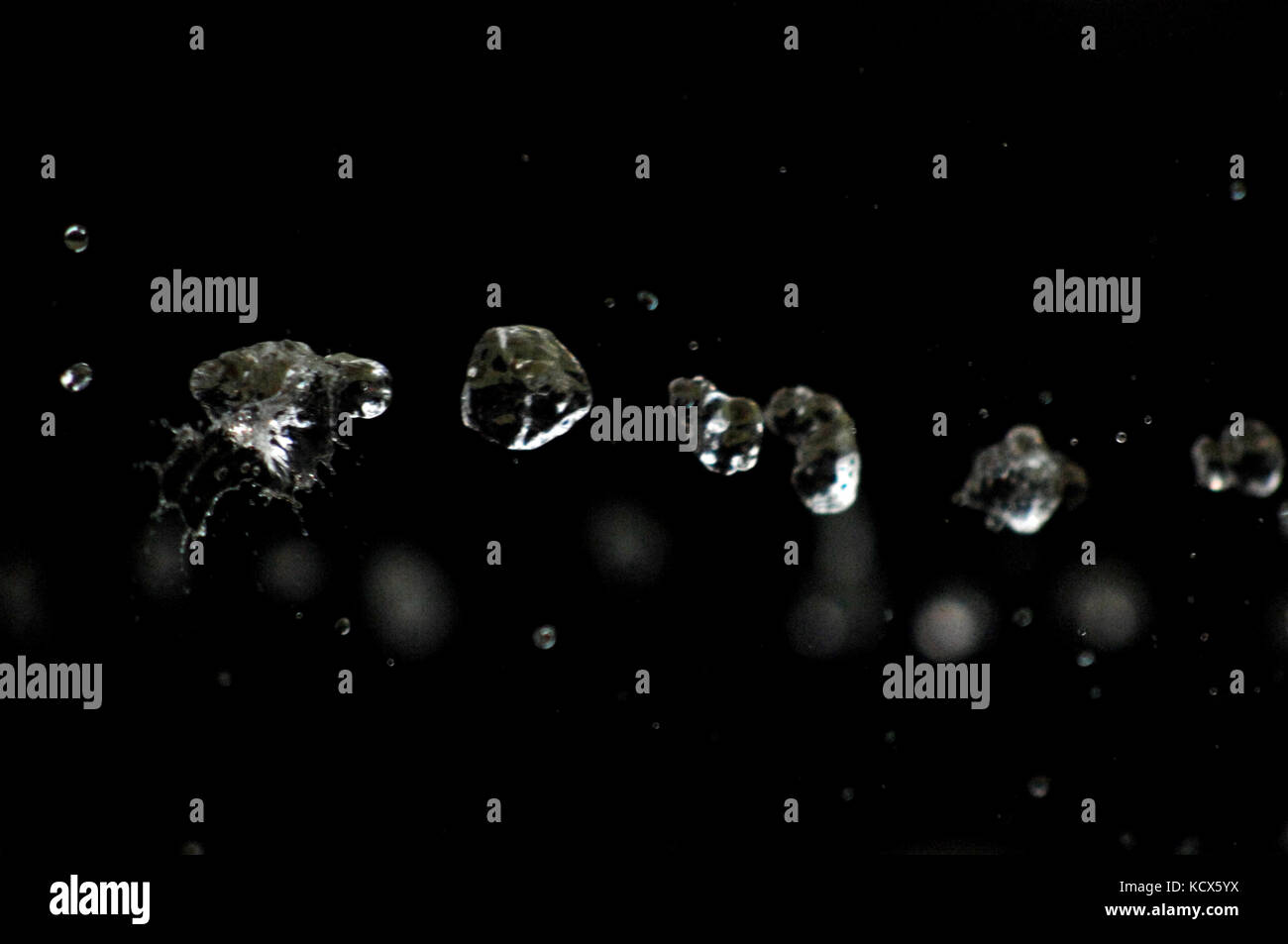 picture of a Water drops levitating in the air in dark. Splashing water ...