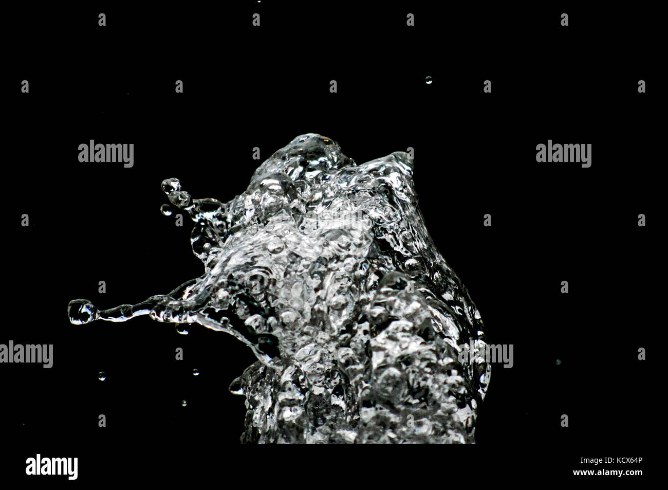 picture of a Water drops levitating in the air in dark. Splashing water ...