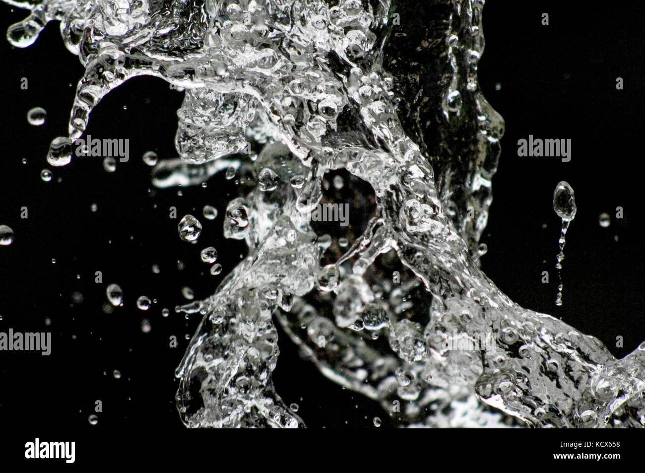 picture of a Water drops levitating in the air in dark. Splashing water ...