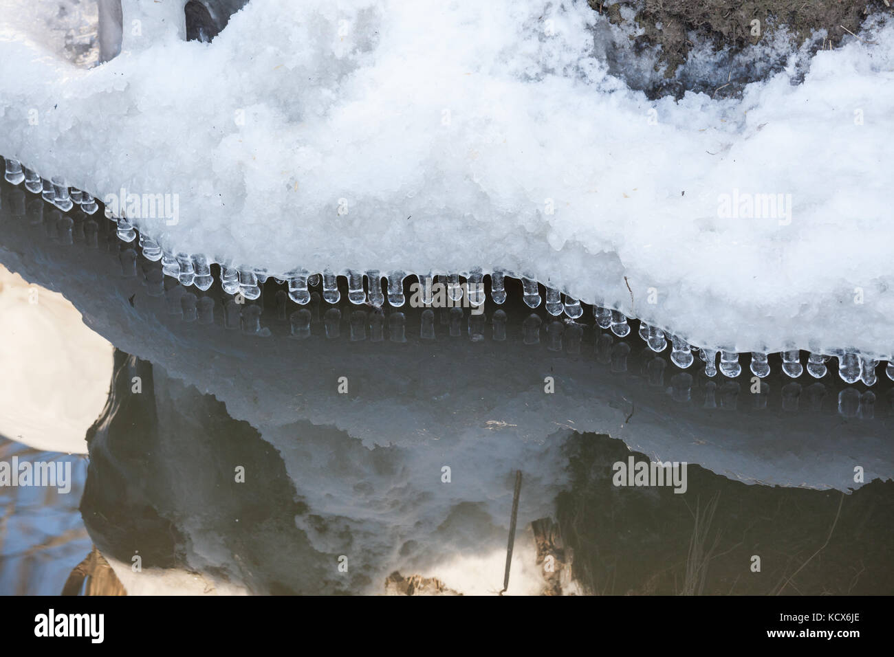 Small round icicles over water Stock Photo - Alamy