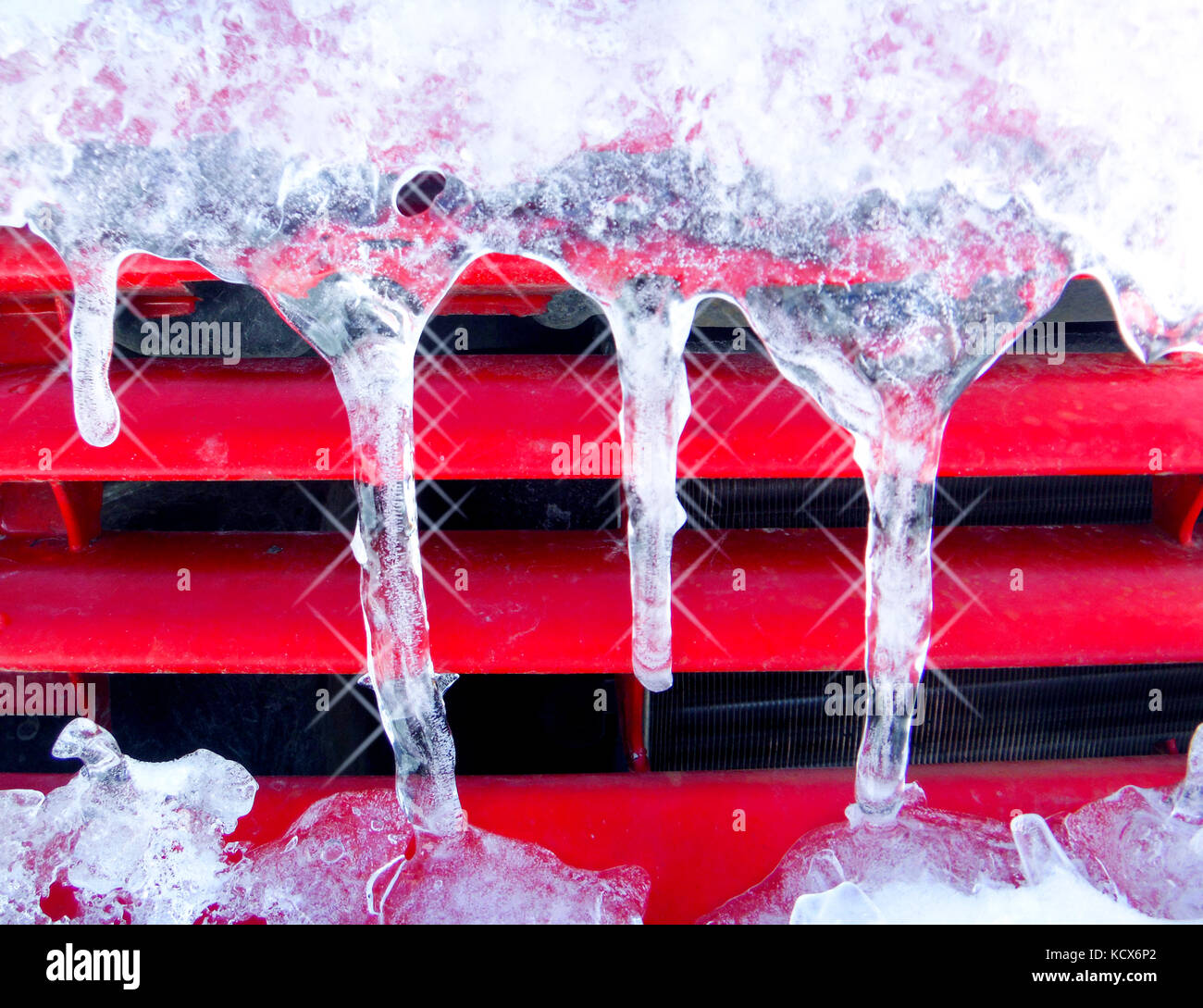 picture of a shiny clear ice icicles hang on a red car surface Stock ...