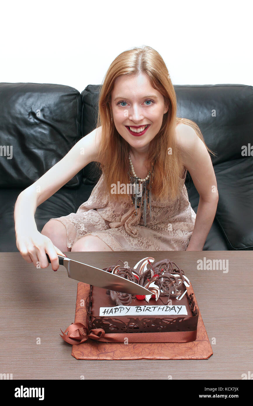 Young girl cutting her chocolate birthday cake Stock Photo - Alamy
