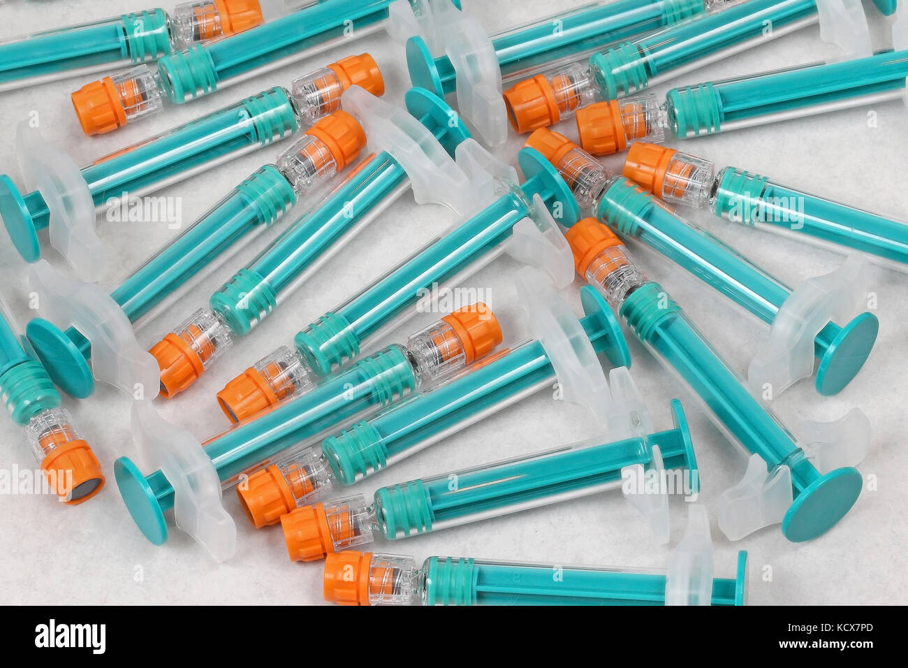 Empty plastic green syringes pile with orange cap Stock Photo - Alamy