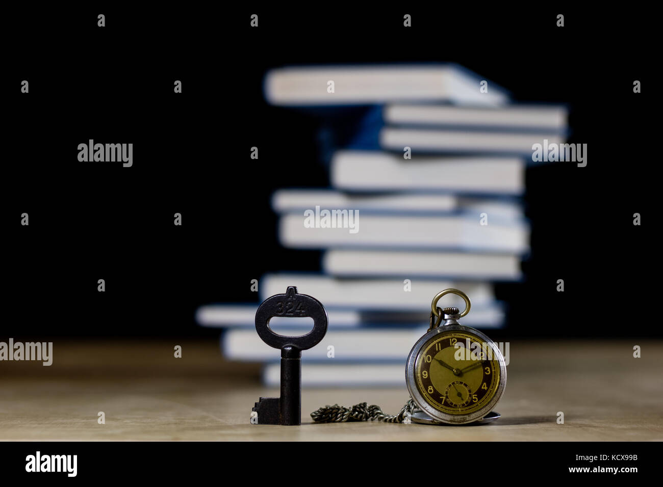 Heap of books reading on a wooden table. Beside lies and watch. Black ...