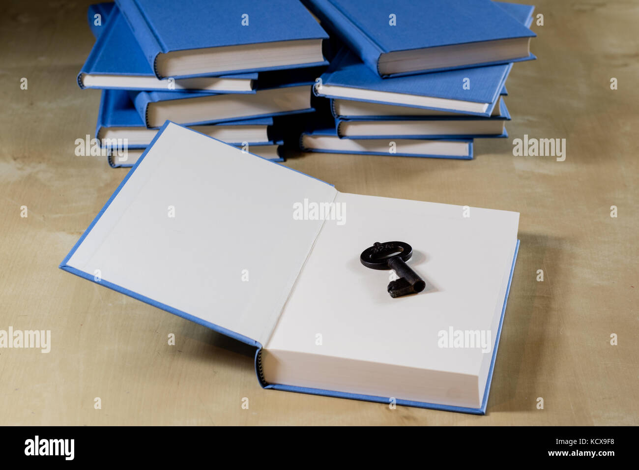 Heap of books reading on a wooden table. Beside lies and key. Black ...