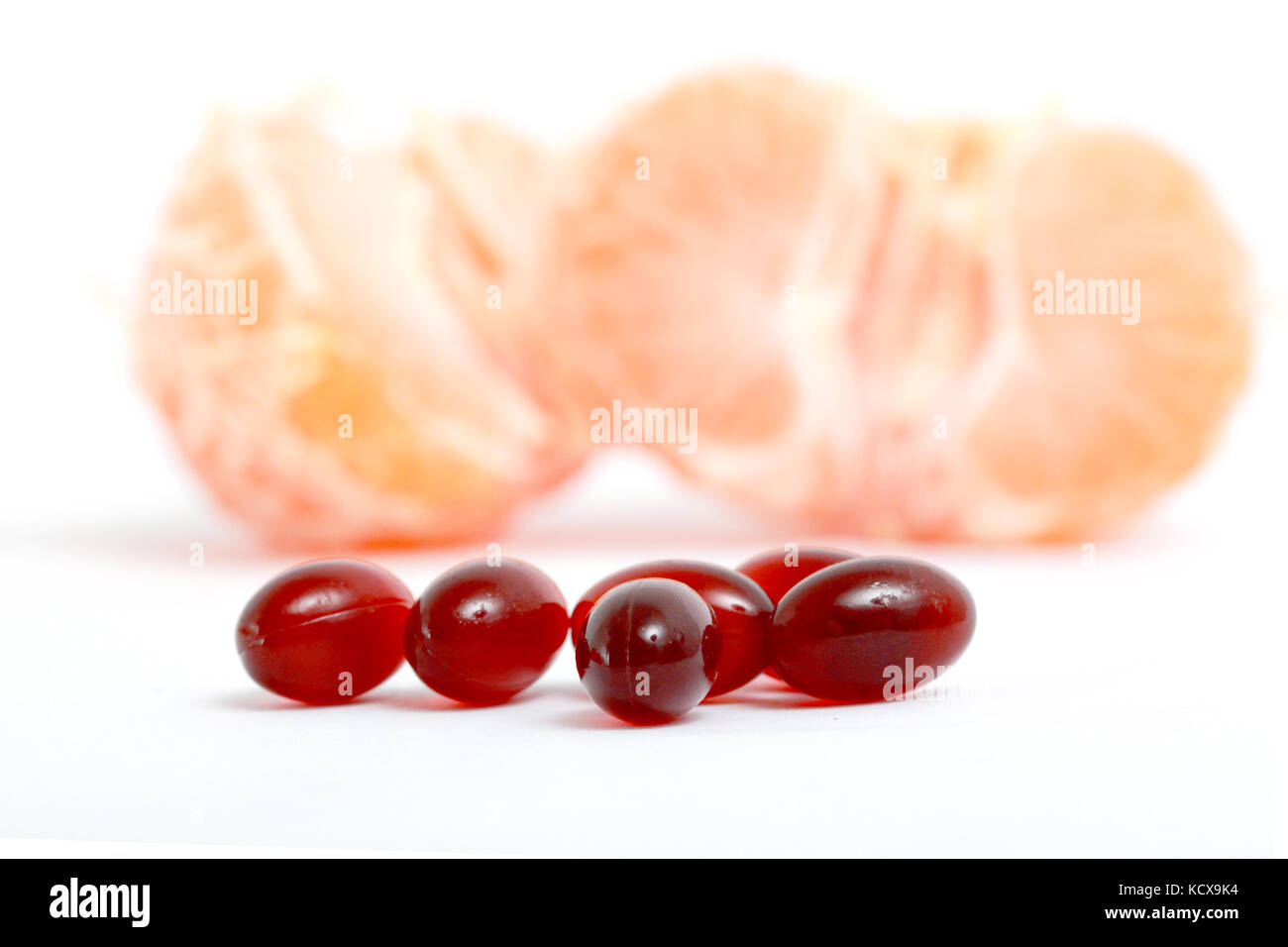 picture of a Tangerines and omega 3 red capsules on white background ...