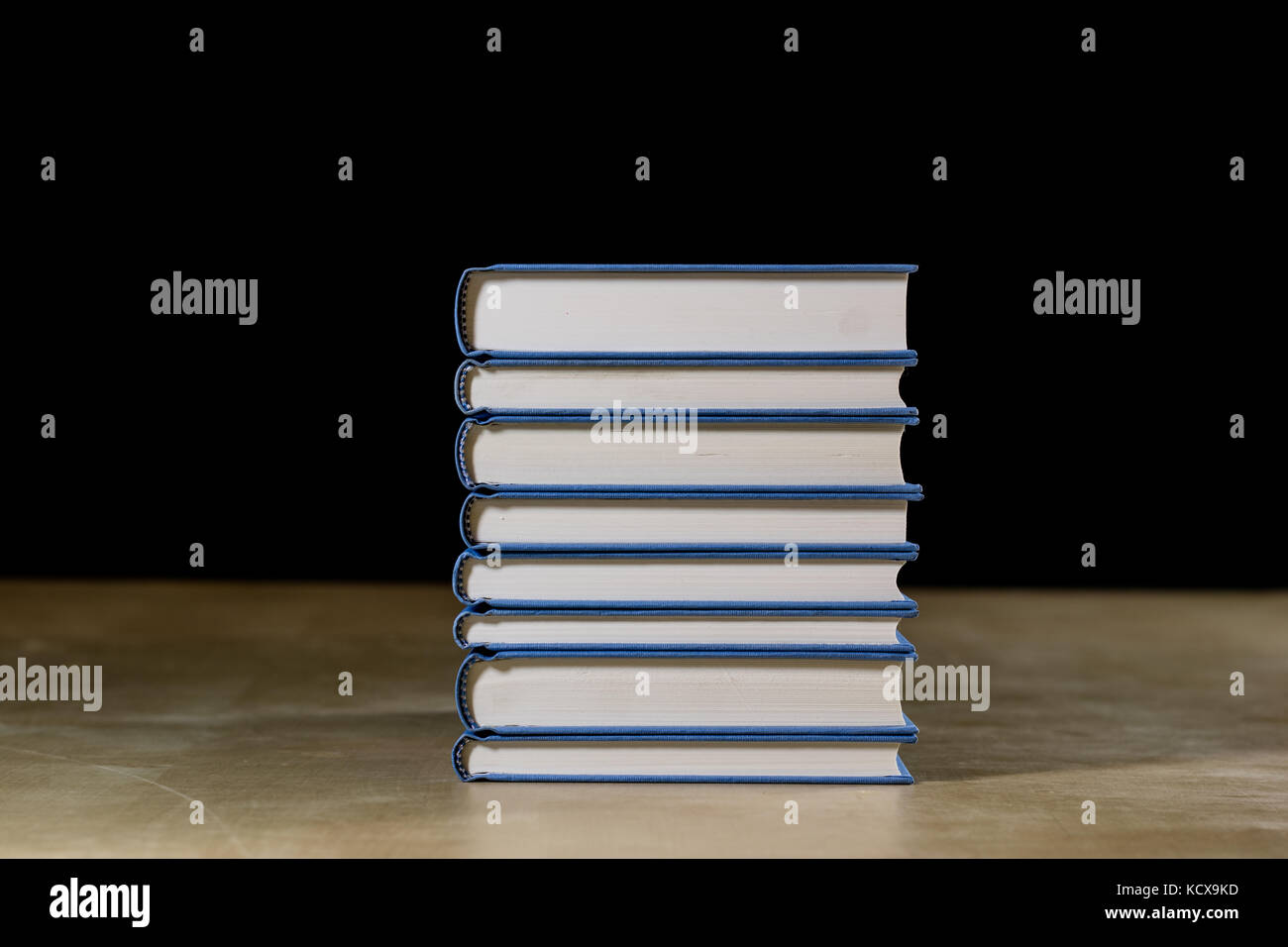 Heap of books reading on a wooden table. Beside lies . Black background ...