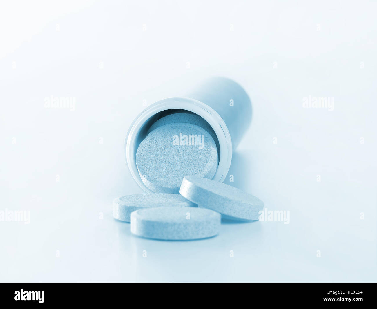 Closeup of blue tablets spilling out of phial Stock Photo - Alamy