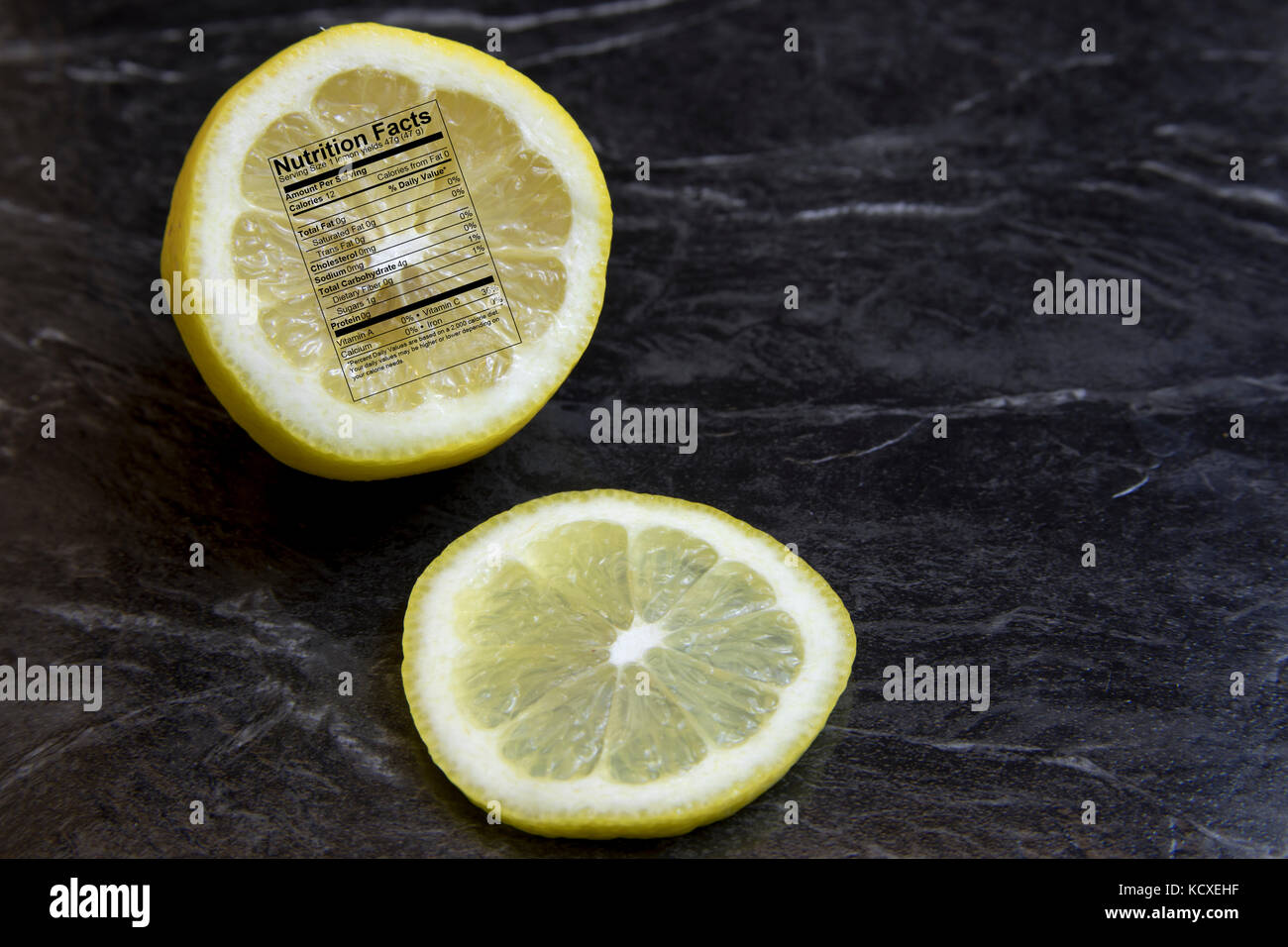 Sliced fresh lemon with nutritional facts label on black Stock Photo ...