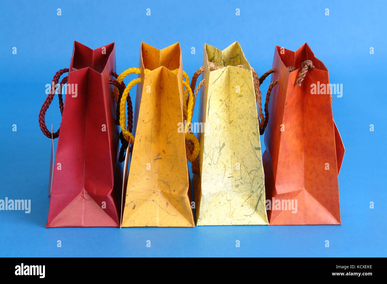 Row of four colorful paper shopping bags Stock Photo - Alamy