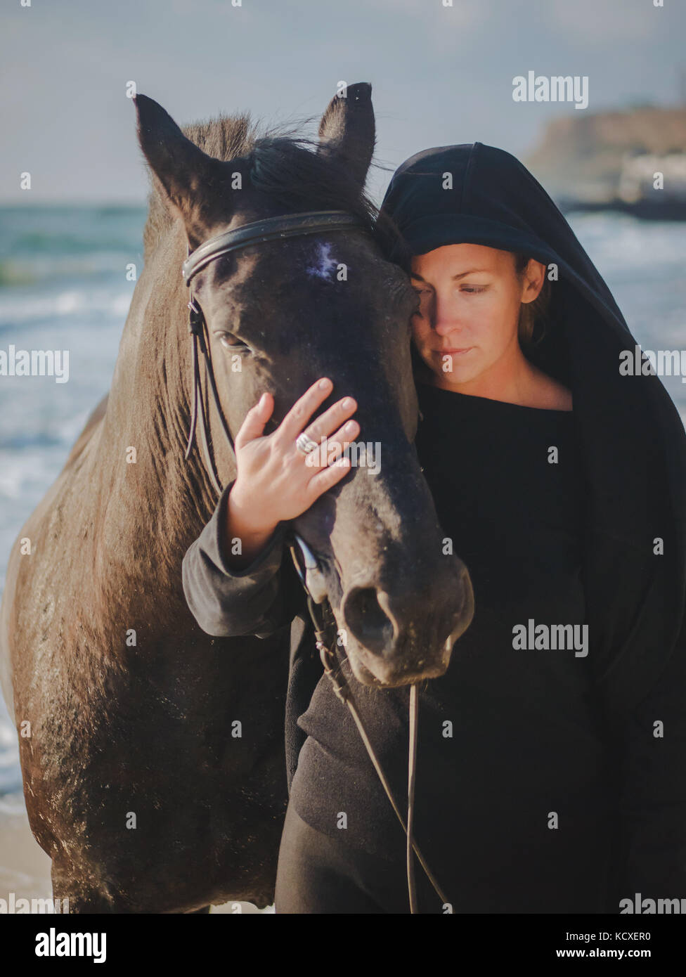 Young Blonde woman stroking and hugging horse. Beautiful lady with her ...