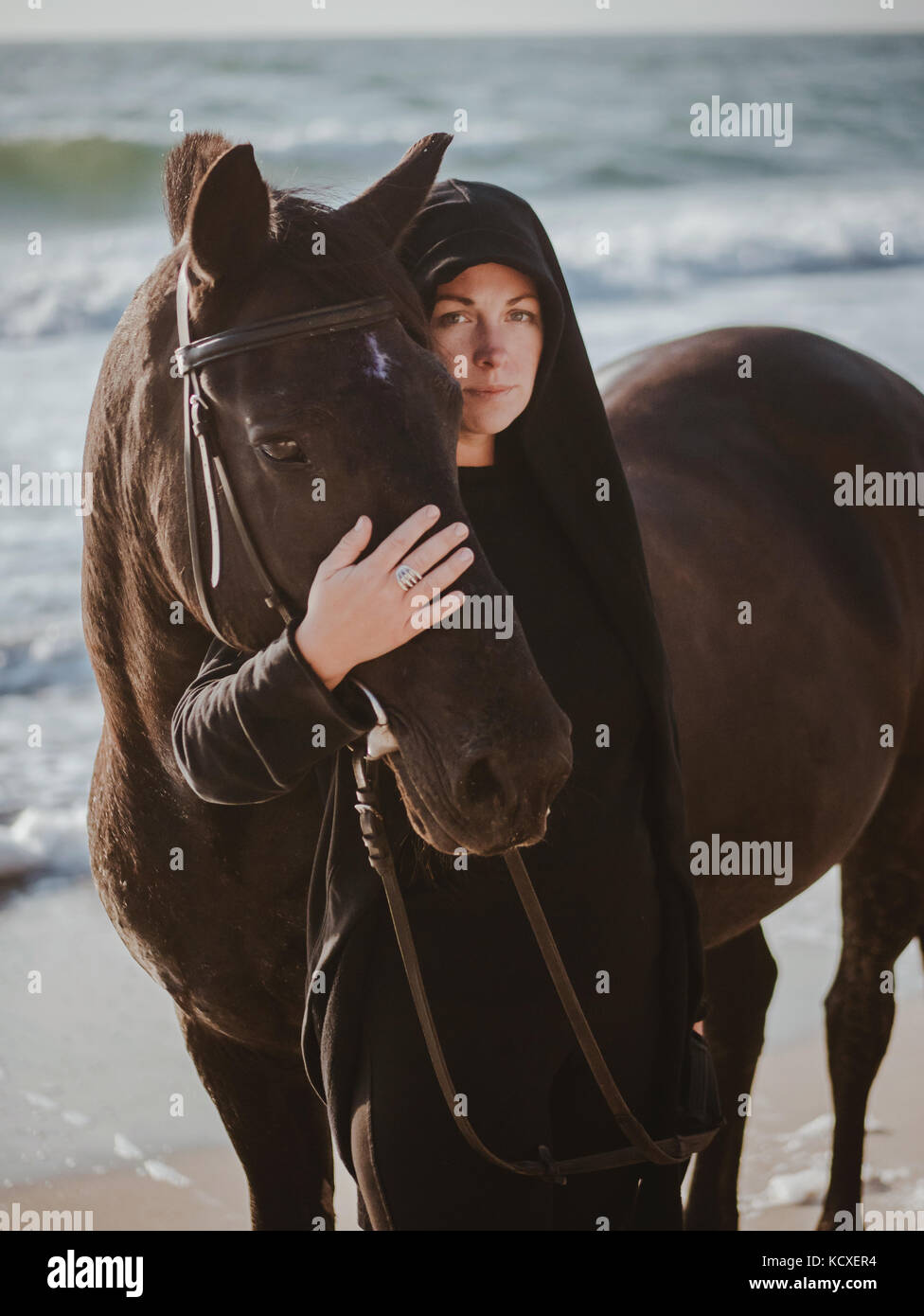 Young Blonde woman stroking and hugging horse. Beautiful lady with her ...