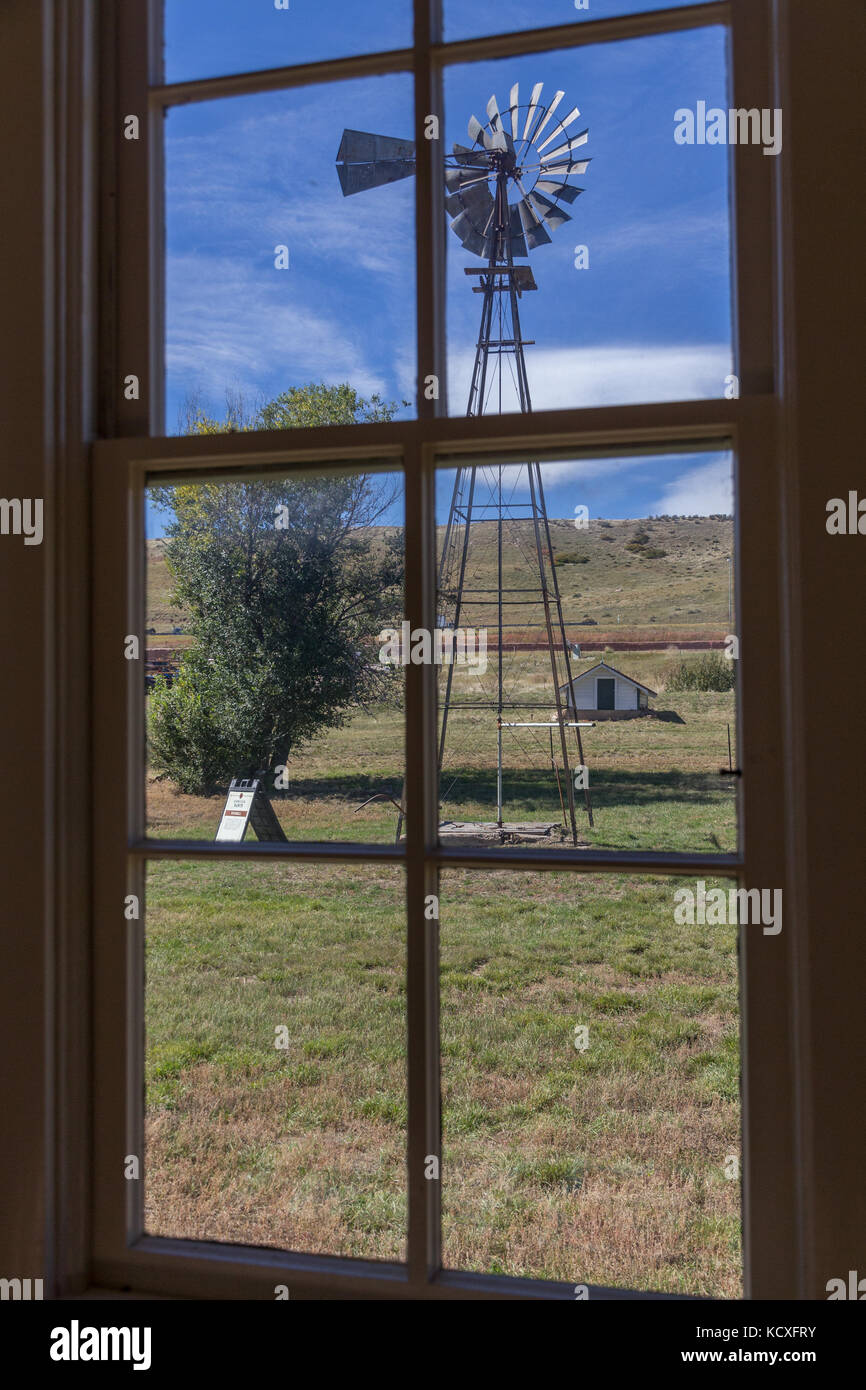 Windmill as seen through the window of a historic homestead at the ...