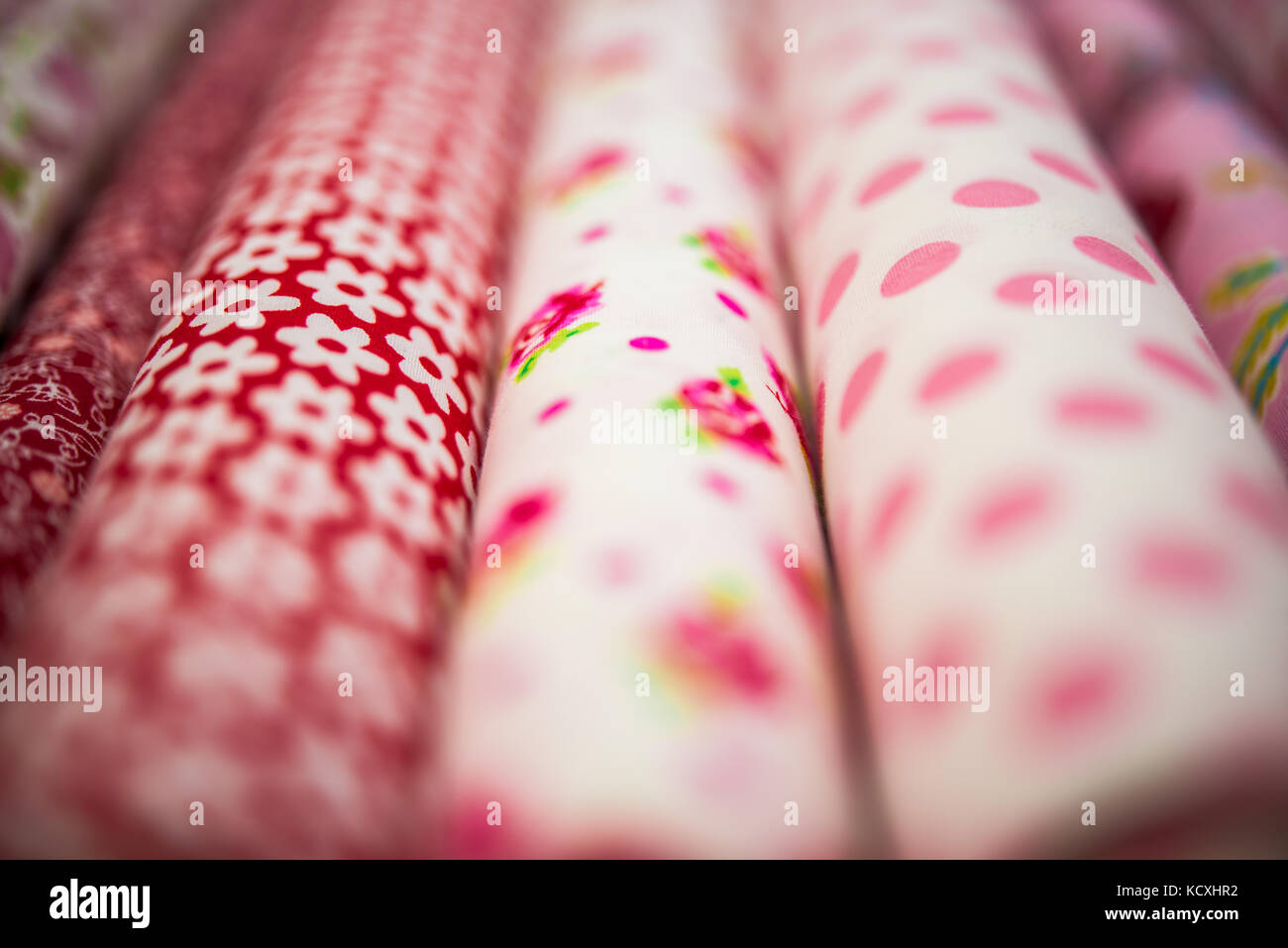 Stack of fabric red pink cloth rolls Stock Photo - Alamy
