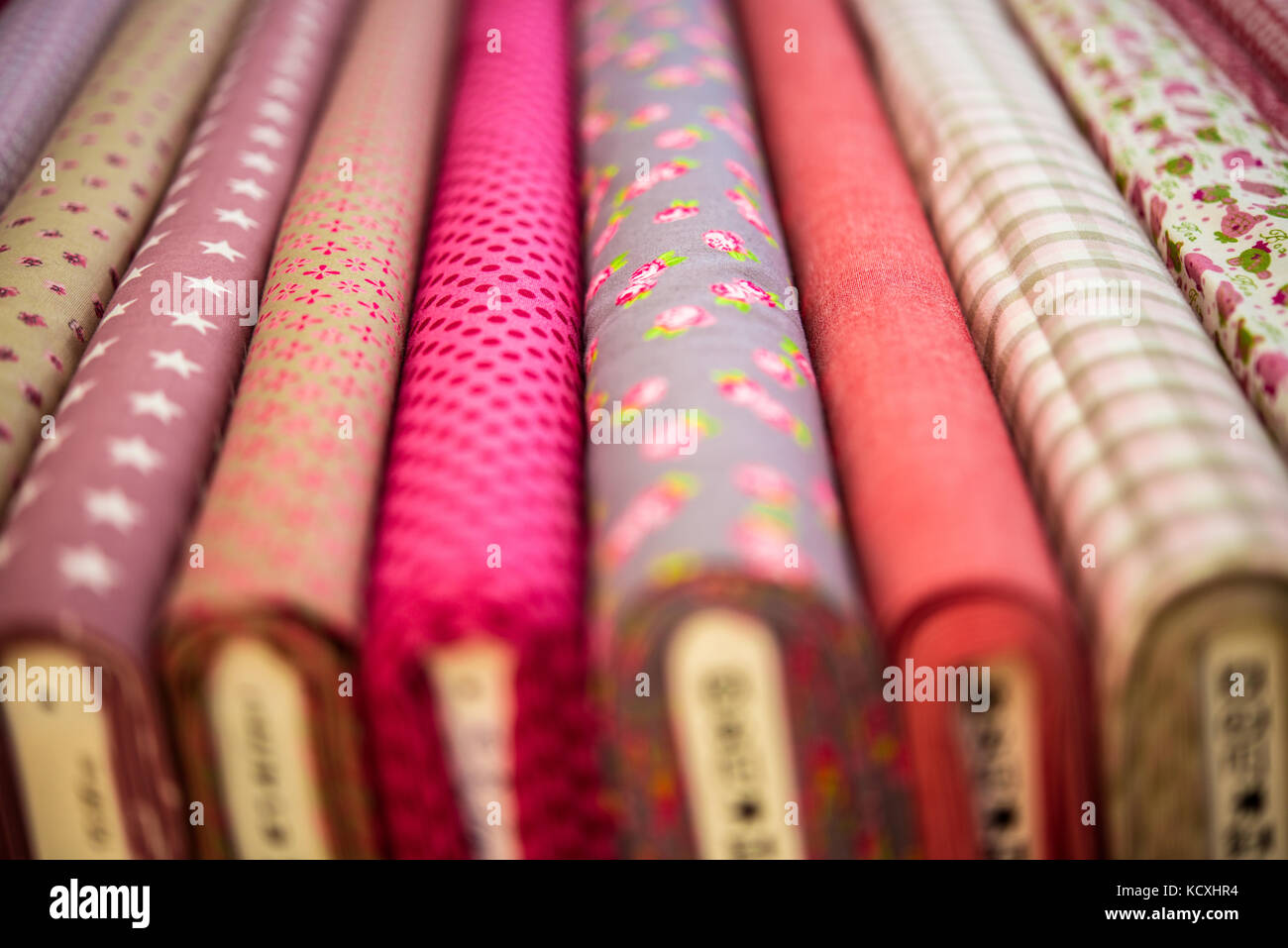 Stack of fabric red pink cloth rolls Stock Photo - Alamy