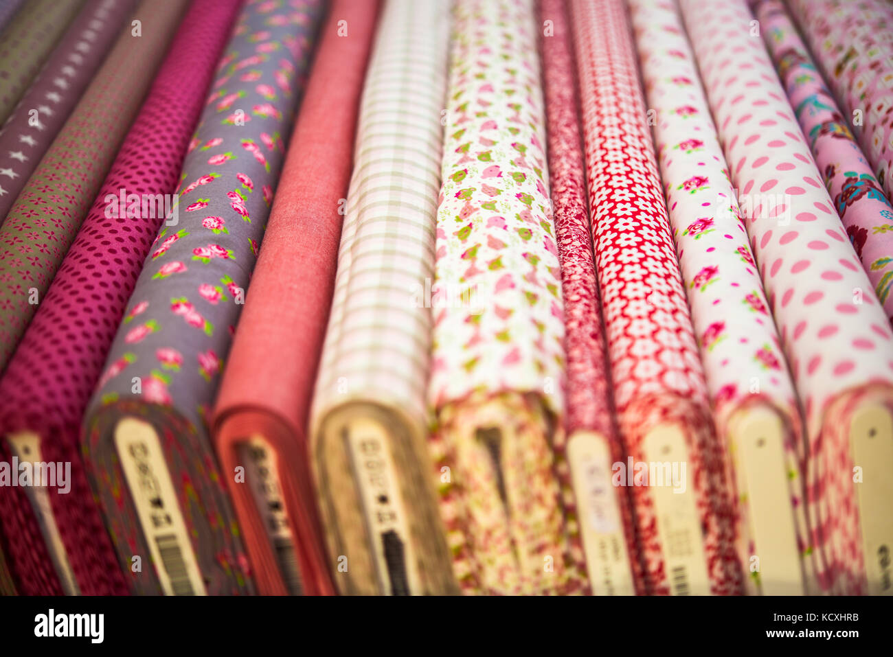 Stack of fabric red pink cloth rolls Stock Photo - Alamy