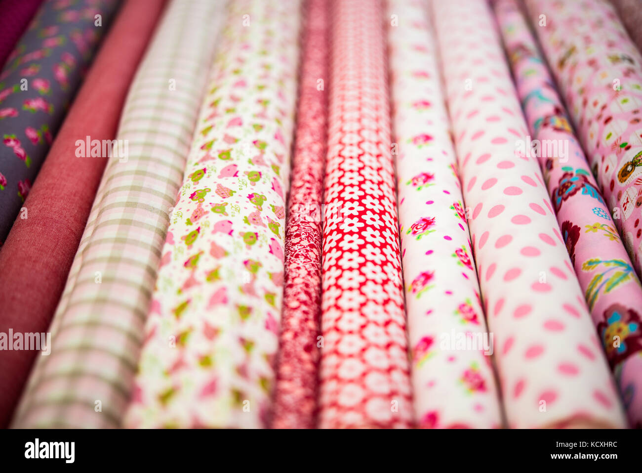 Stack of fabric red pink cloth rolls Stock Photo - Alamy