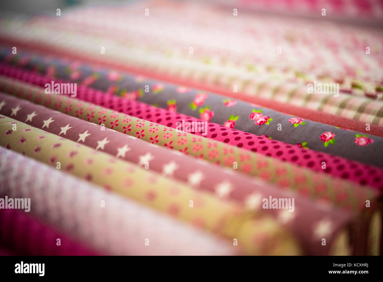 Stack of fabric red pink cloth rolls Stock Photo - Alamy