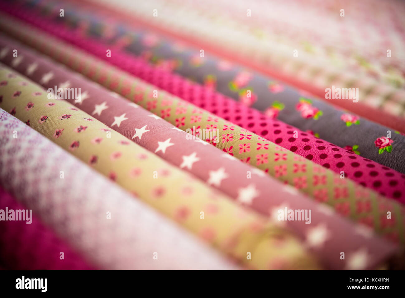 Stack of fabric red pink cloth rolls Stock Photo - Alamy