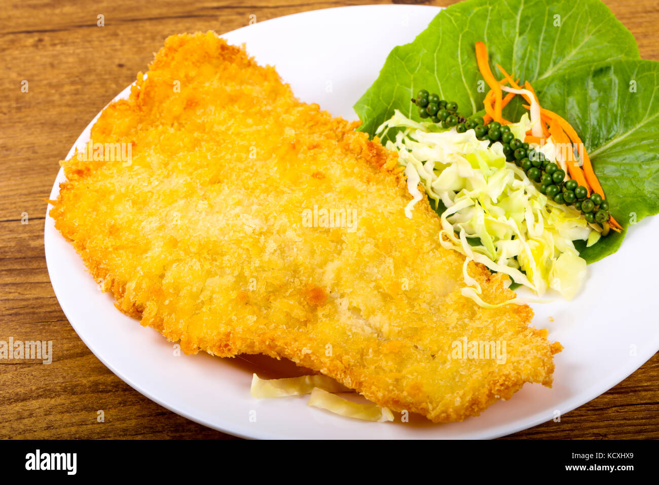 Fried Dory fish with salad on the wood background Stock Photo - Alamy
