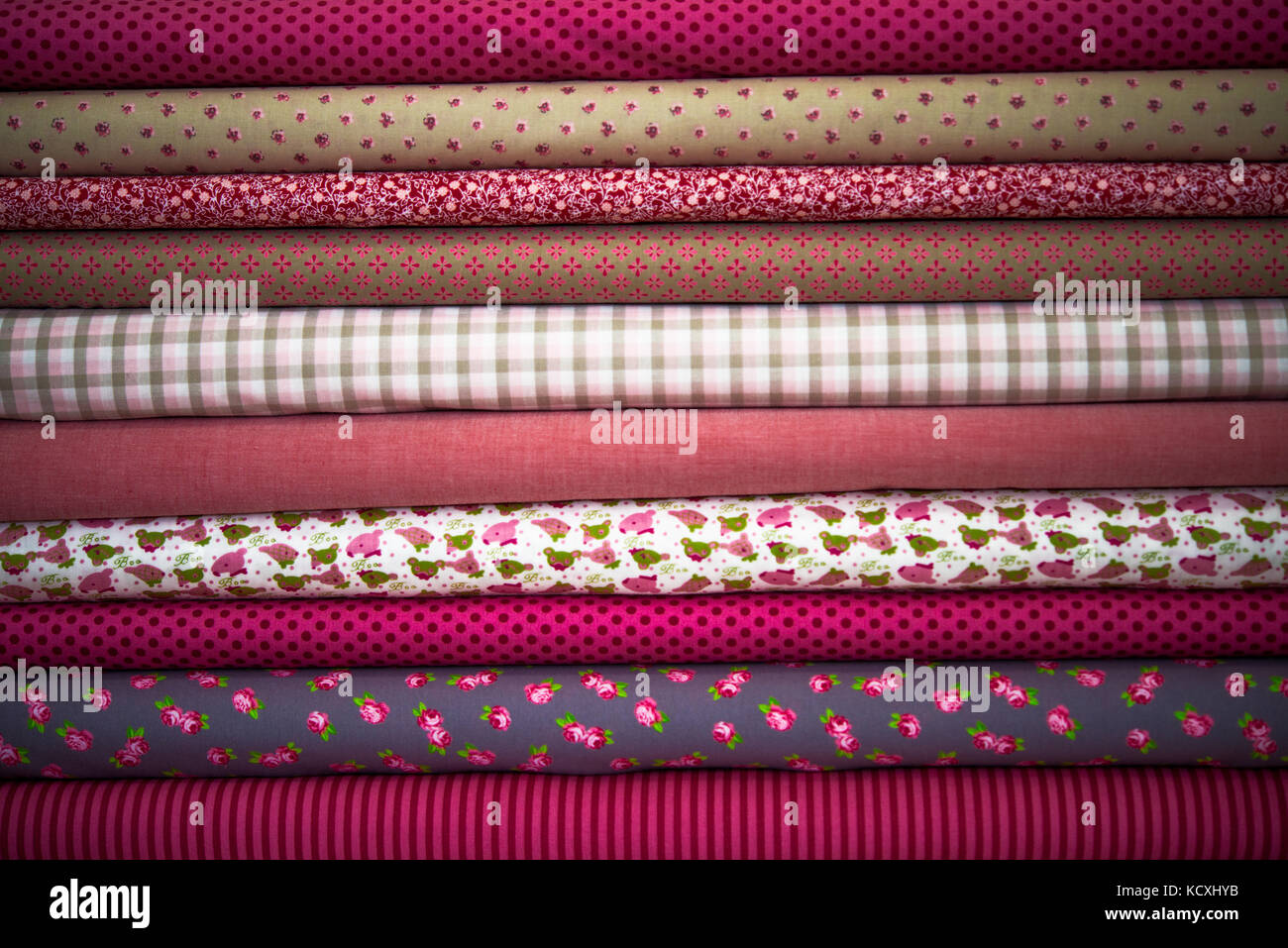 Stack of fabric red pink cloth rolls Stock Photo - Alamy