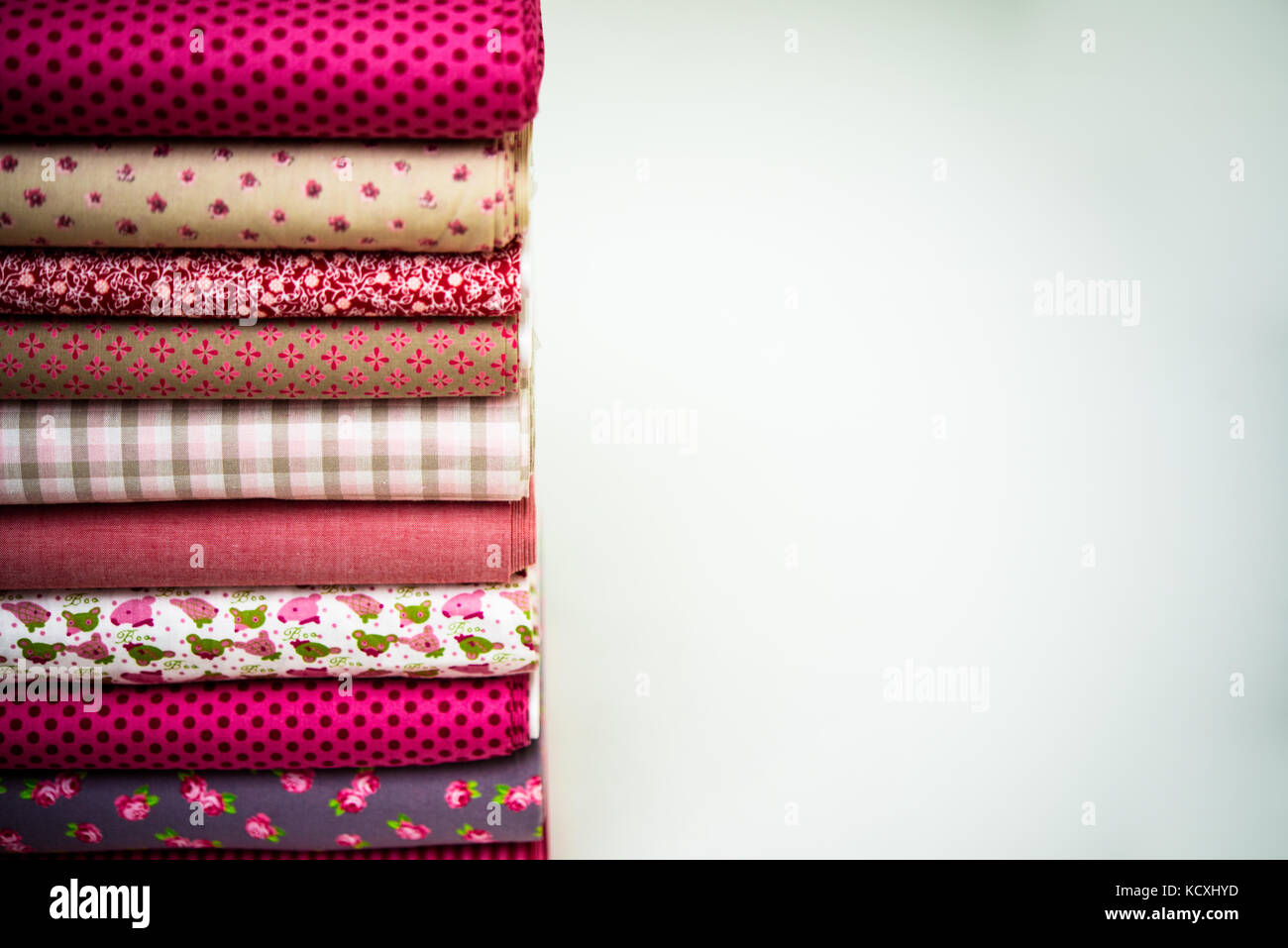 Stack of fabric red pink cloth rolls Stock Photo - Alamy