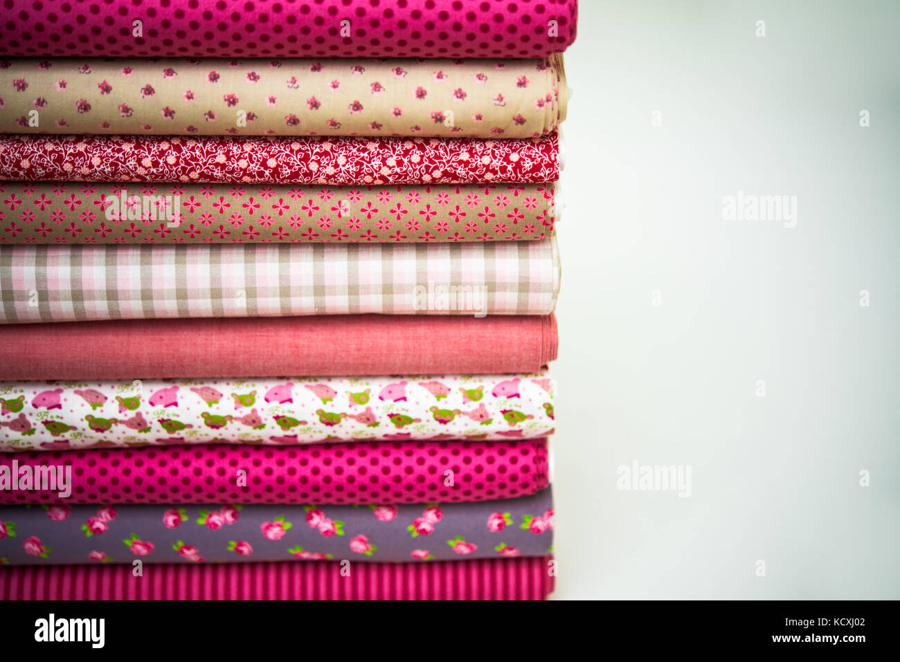 Stack of fabric red pink cloth rolls Stock Photo - Alamy