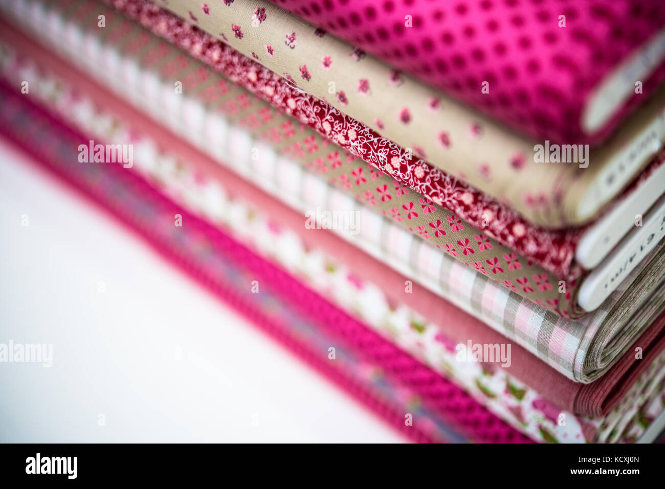 Stack of fabric red pink cloth rolls Stock Photo - Alamy