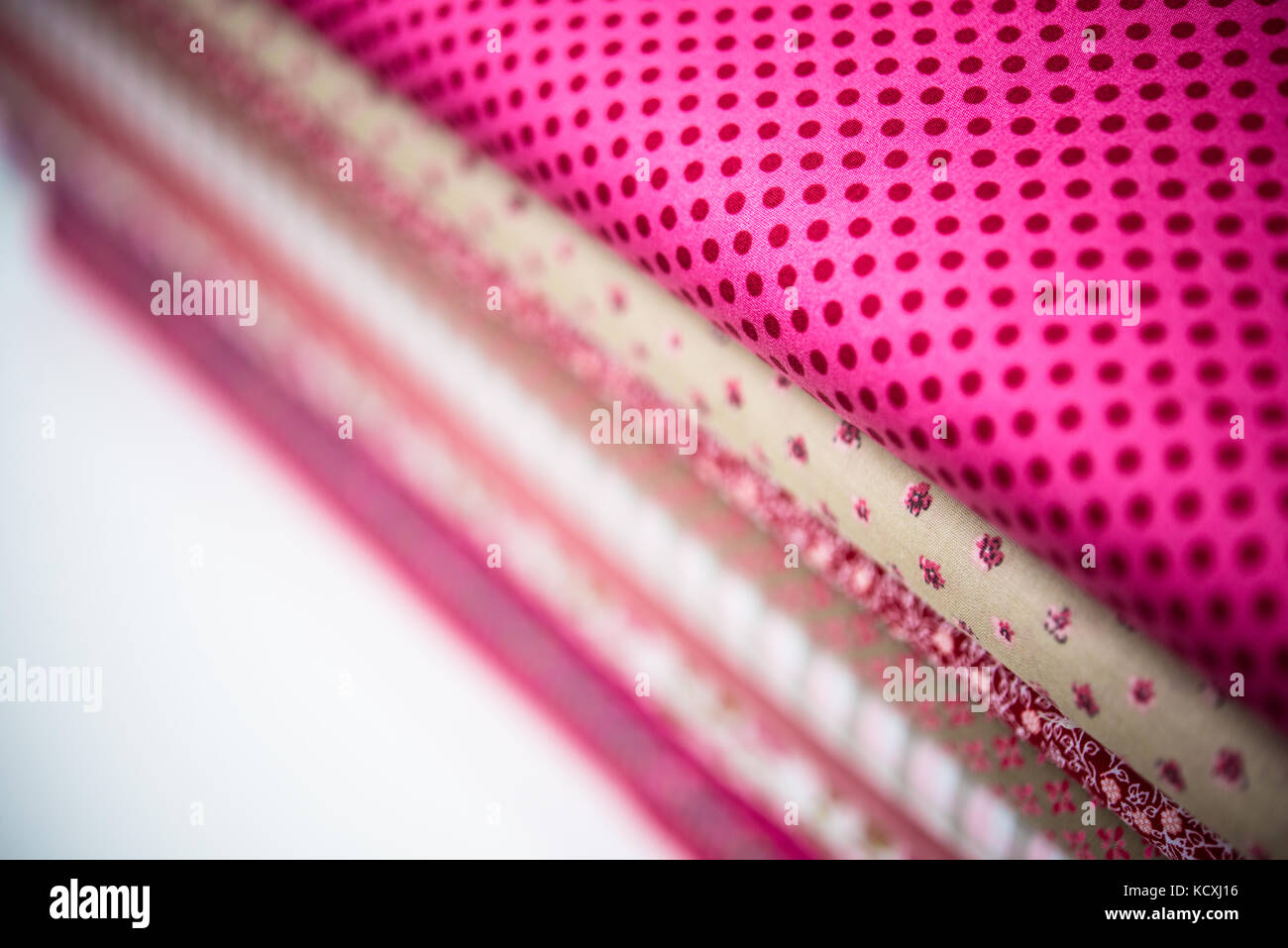 Stack of fabric red pink cloth rolls Stock Photo - Alamy
