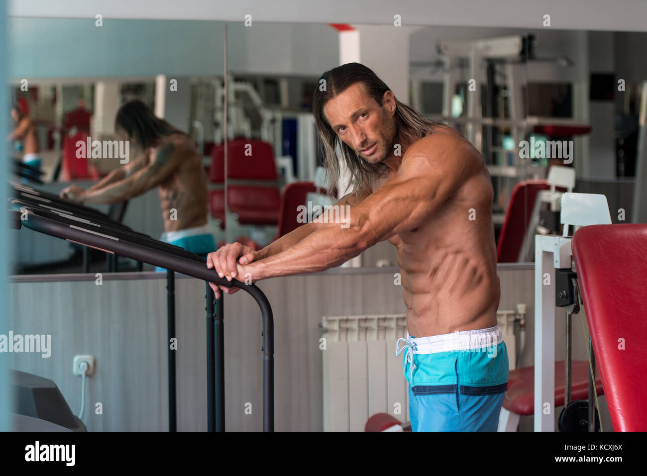 Attractive muscular male bodybuilder leaning hi-res stock photography ...