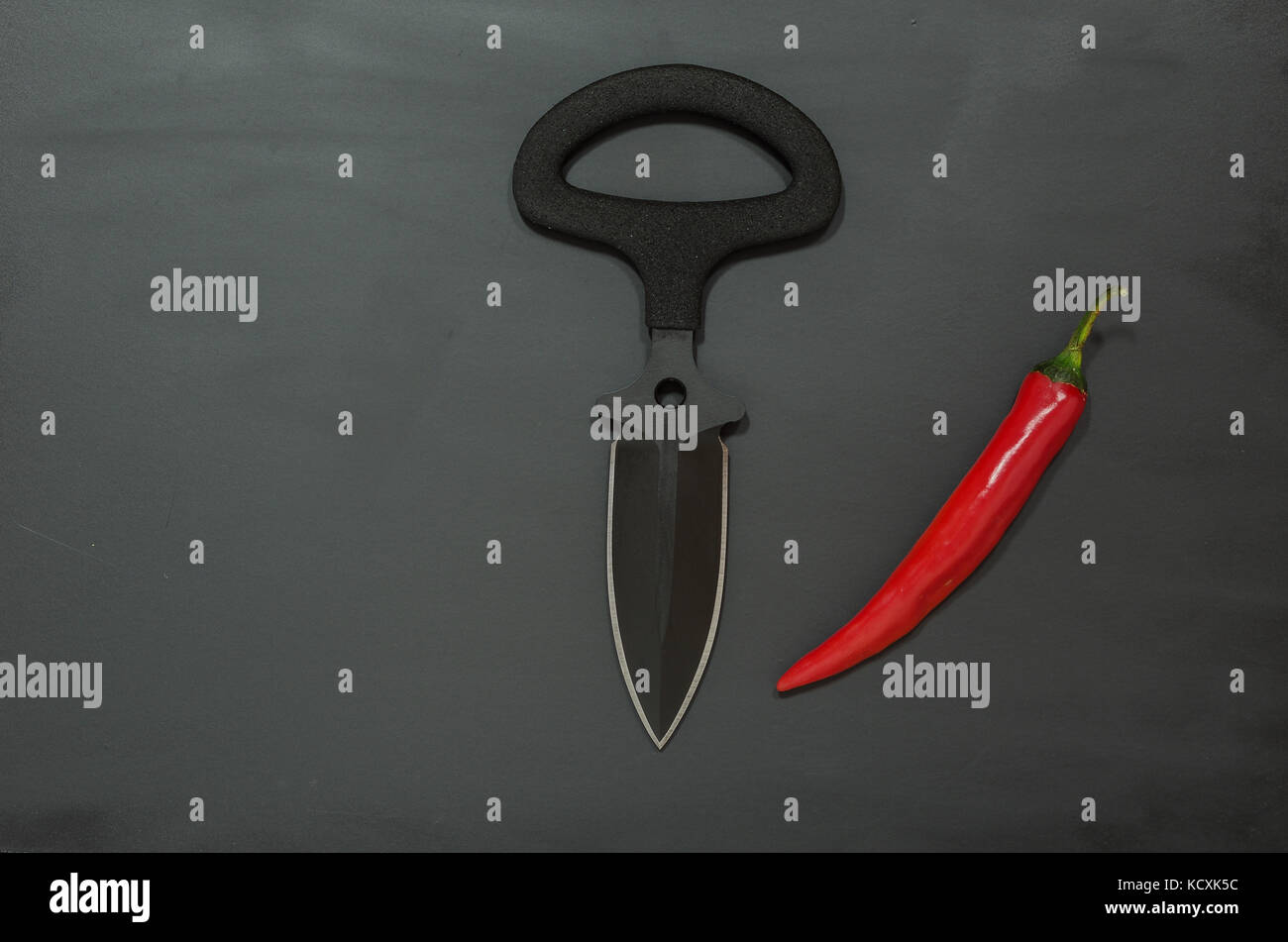 Sharpness and strength. Knife and red chilli papper. Black and red ...