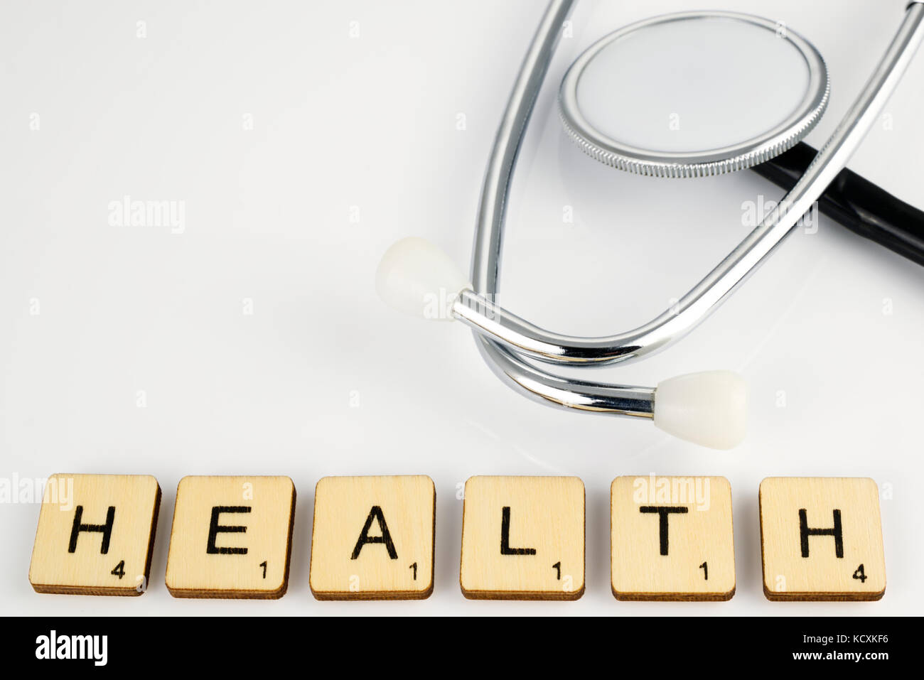 The word Health written in letter tiles with a black stethoscope ...