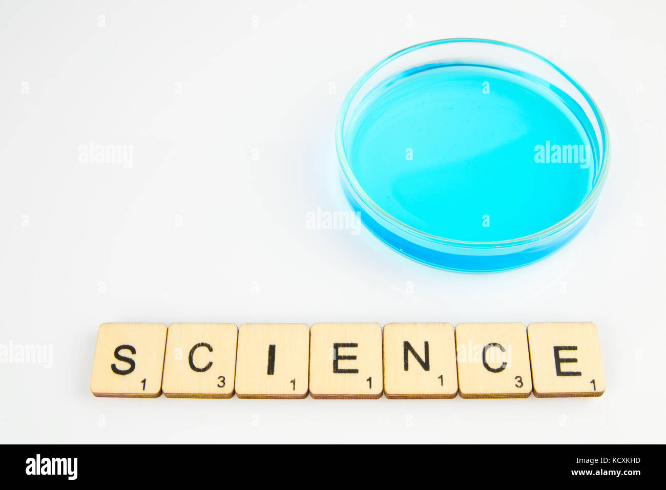 word science written in letter tiles with a petri dish of blue copper ...