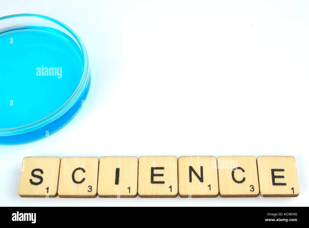 word science written in letter tiles with a petri dish of blue copper ...